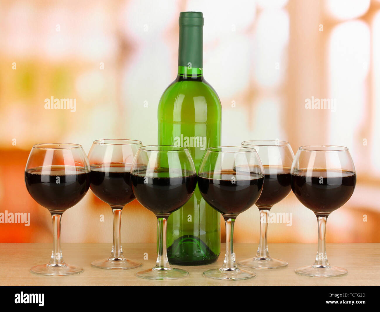 Red wine in glass and bottle on room background Stock Photo - Alamy