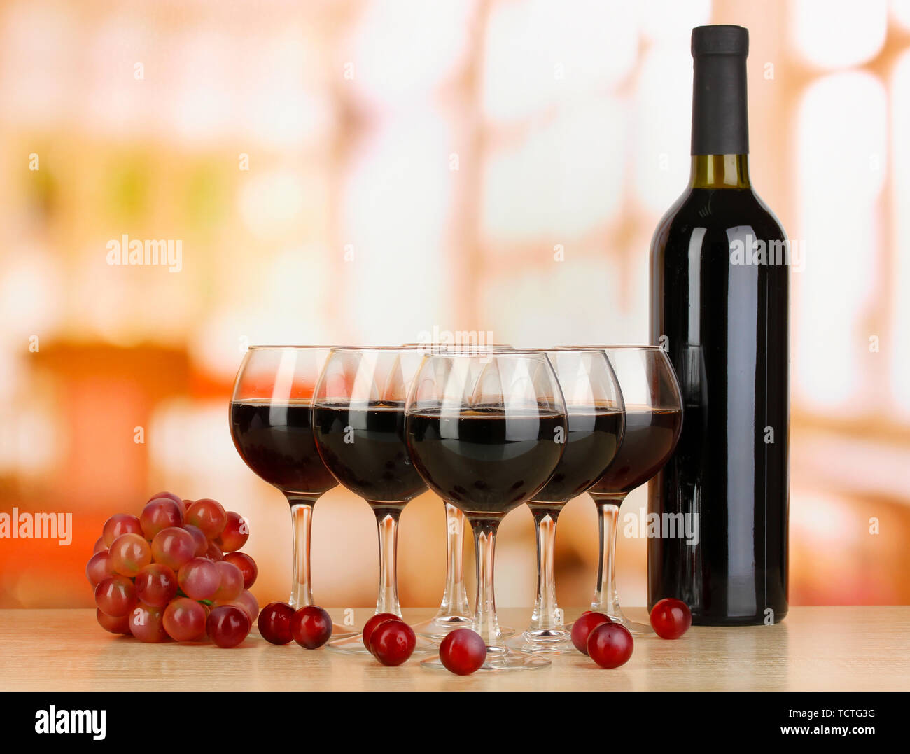 Red wine in glass and bottle on room background Stock Photo - Alamy