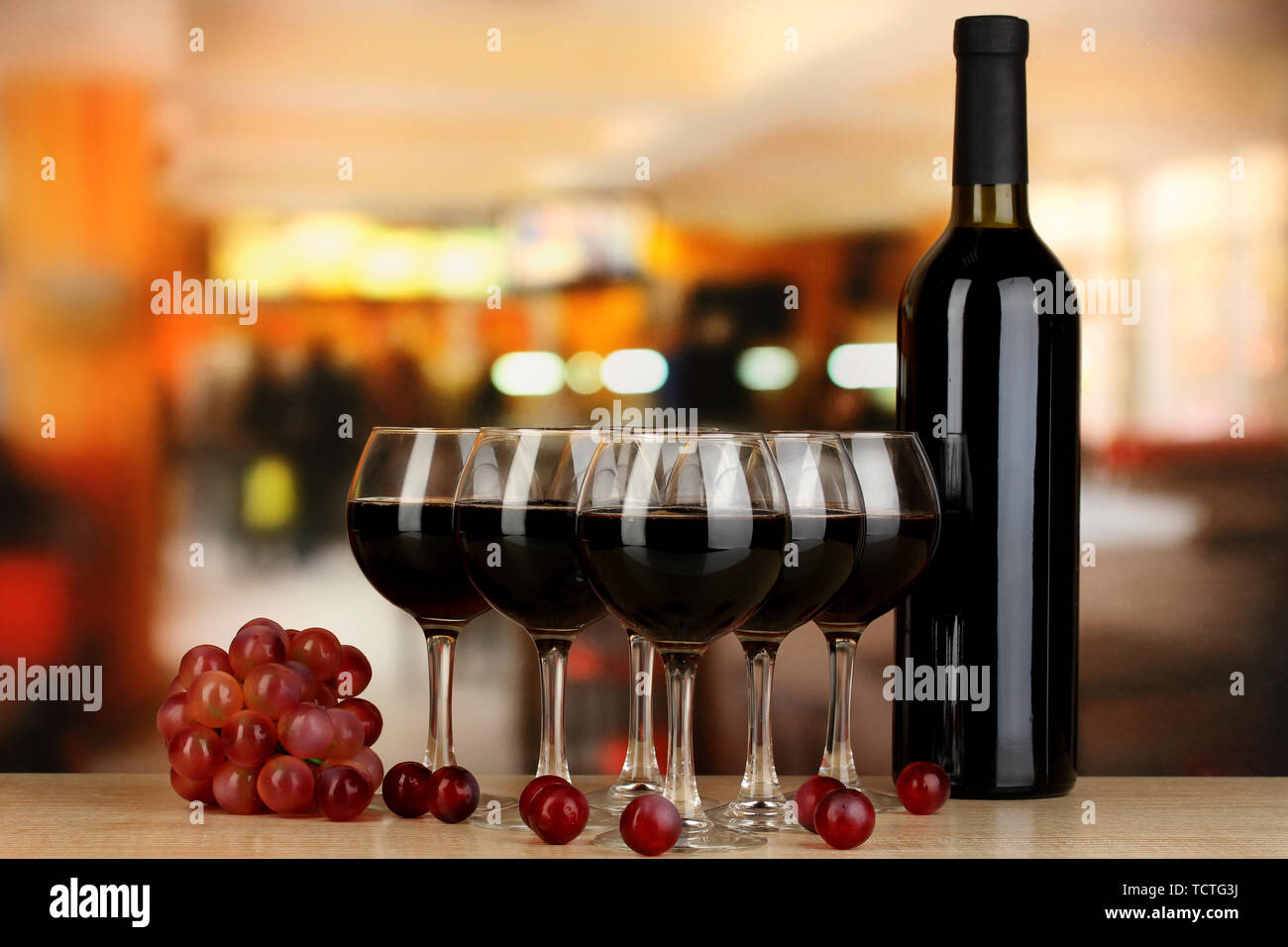 Red wine in glass and bottle on room background Stock Photo - Alamy