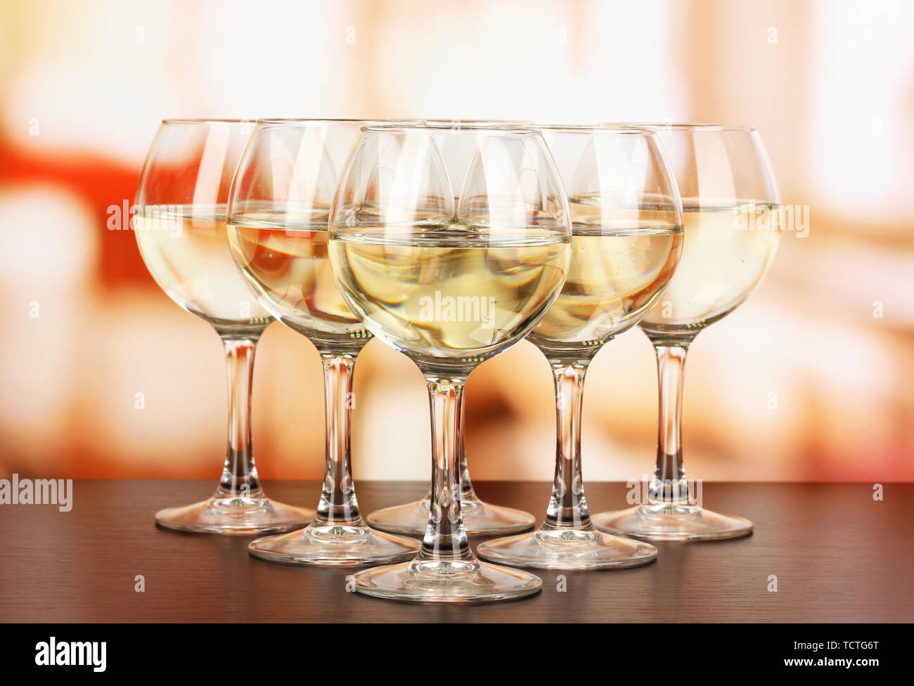 White wine in glass on room background Stock Photo - Alamy