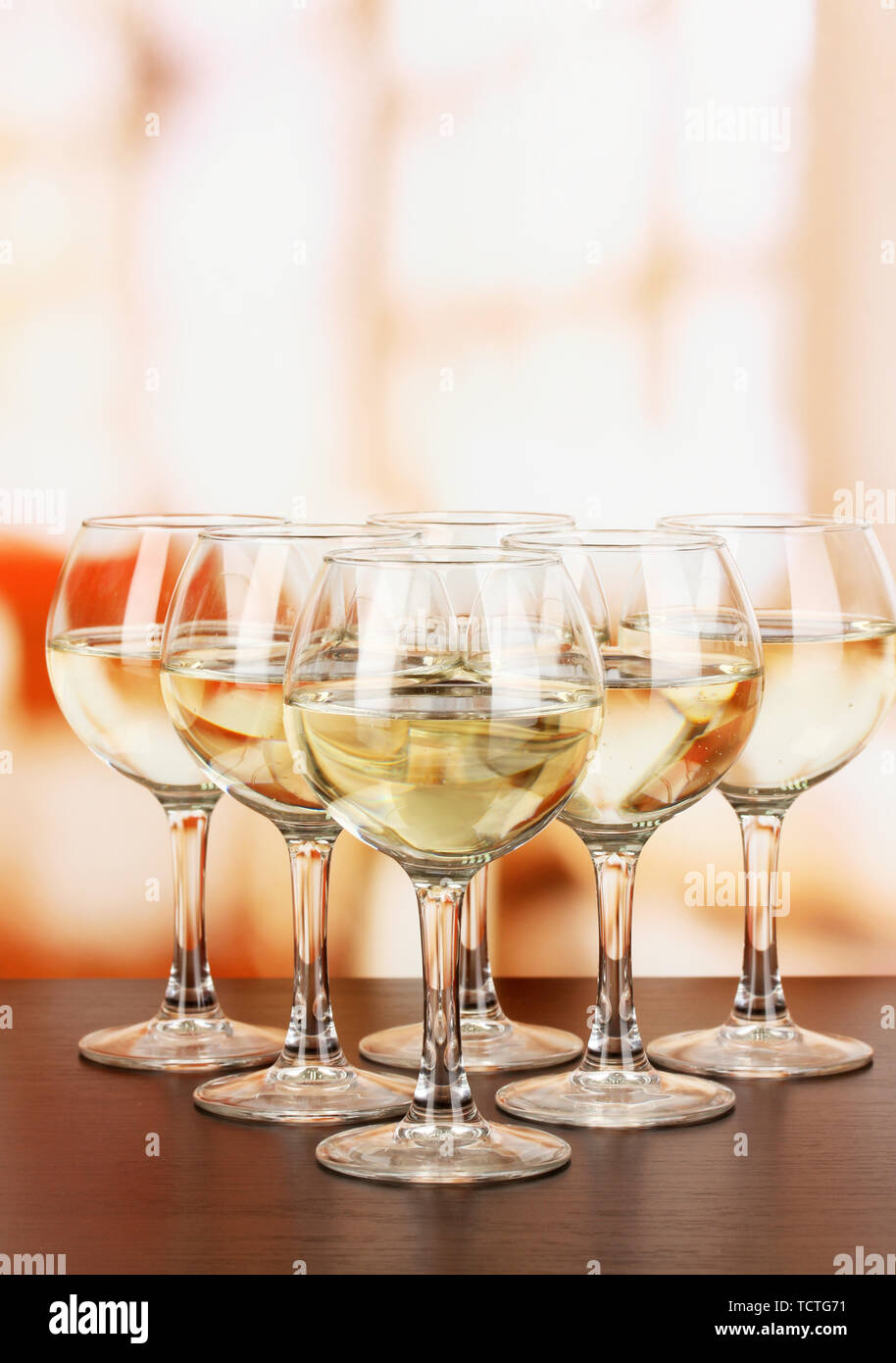 White wine in glass on room background Stock Photo - Alamy