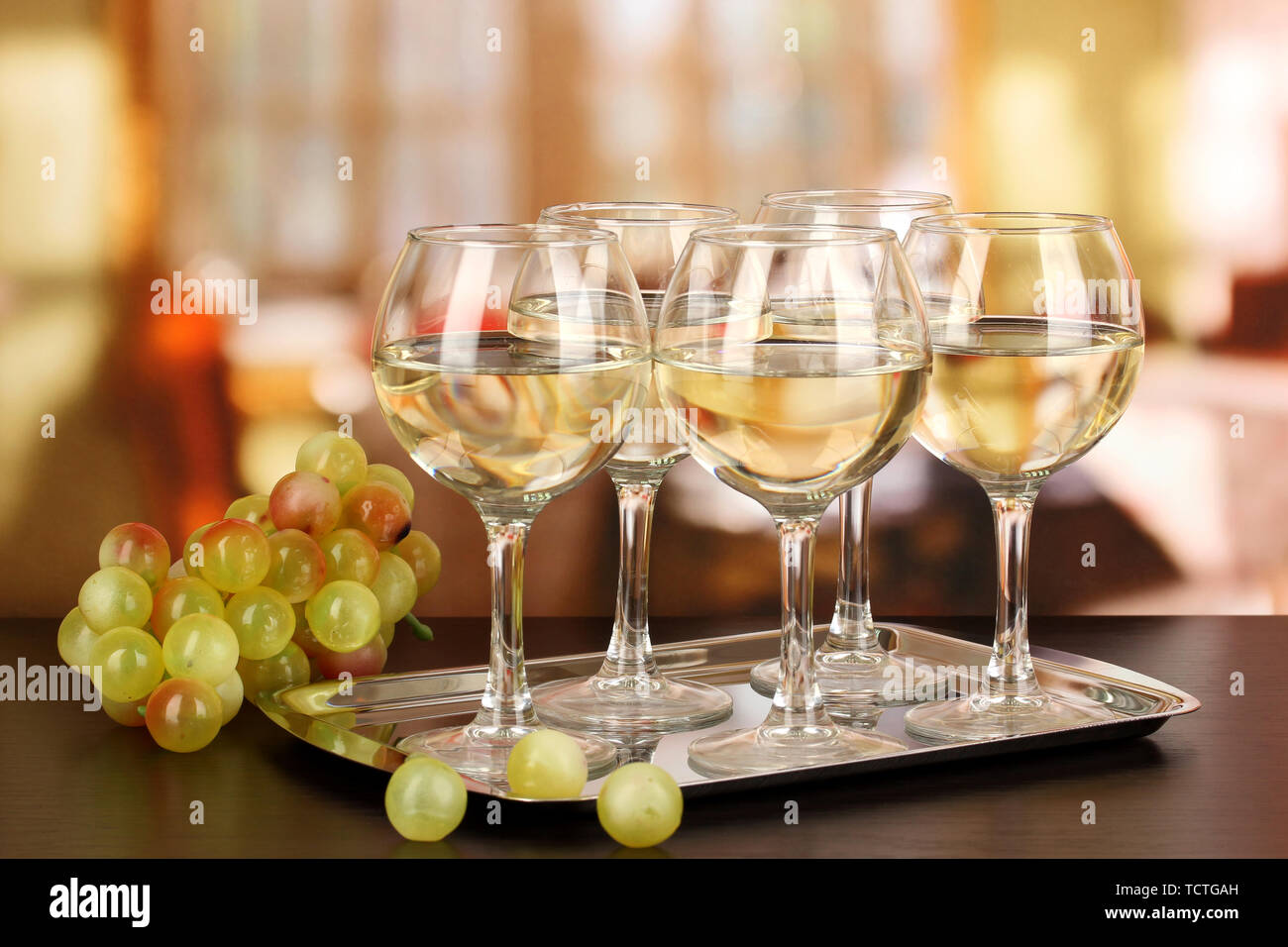 White wine in glass on room background Stock Photo - Alamy