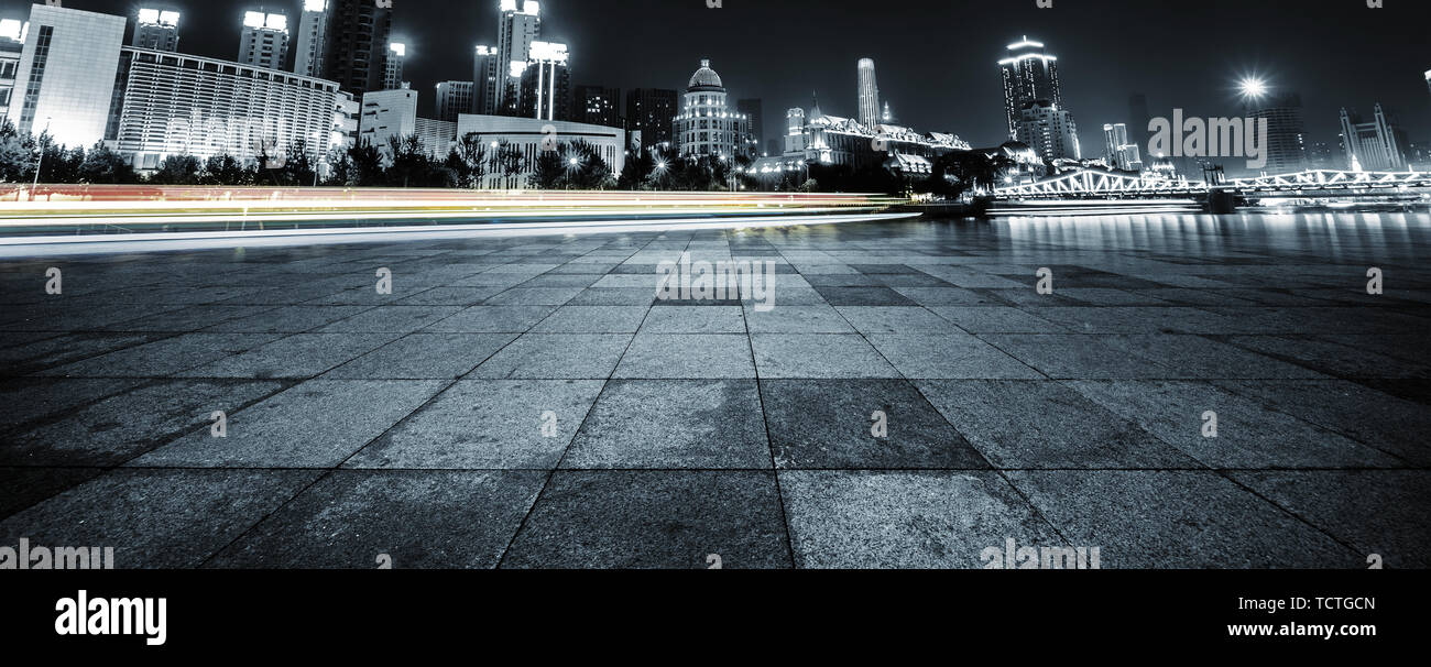 light trails and cityscape with empty road floor Stock Photo - Alamy