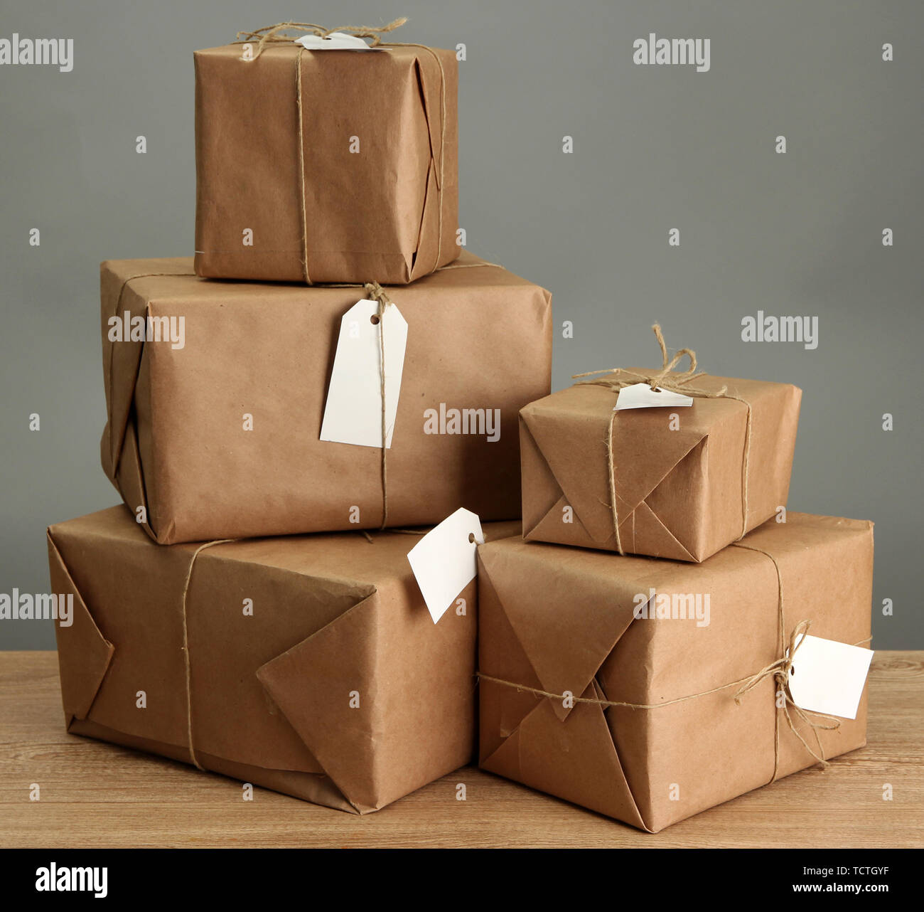 parcels boxes with kraft paper, on wooden table on grey background ...