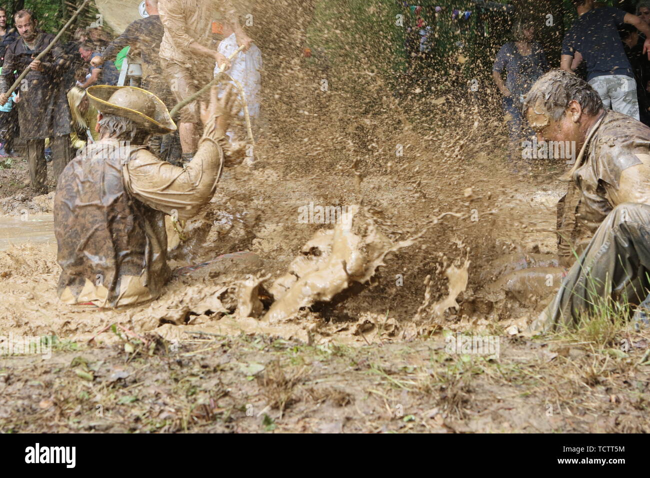 Hergisdorf, Germany. 10th June, 2019. Men jump into a mud hole at the ...