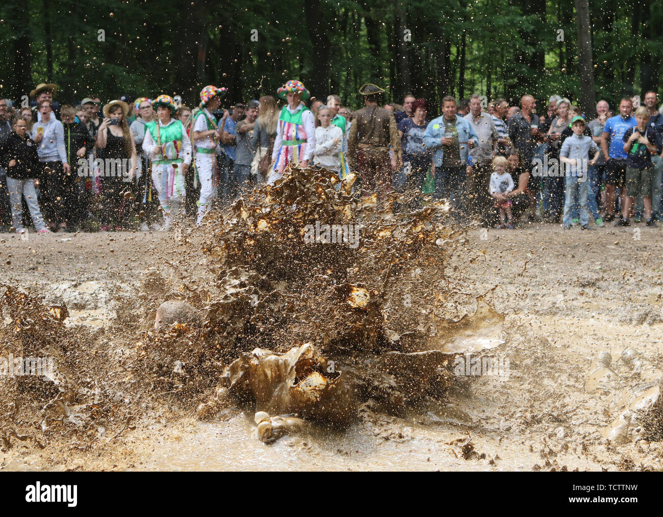 Hergisdorf, Germany. 10th June, 2019. Men jump into a mud hole at the ...