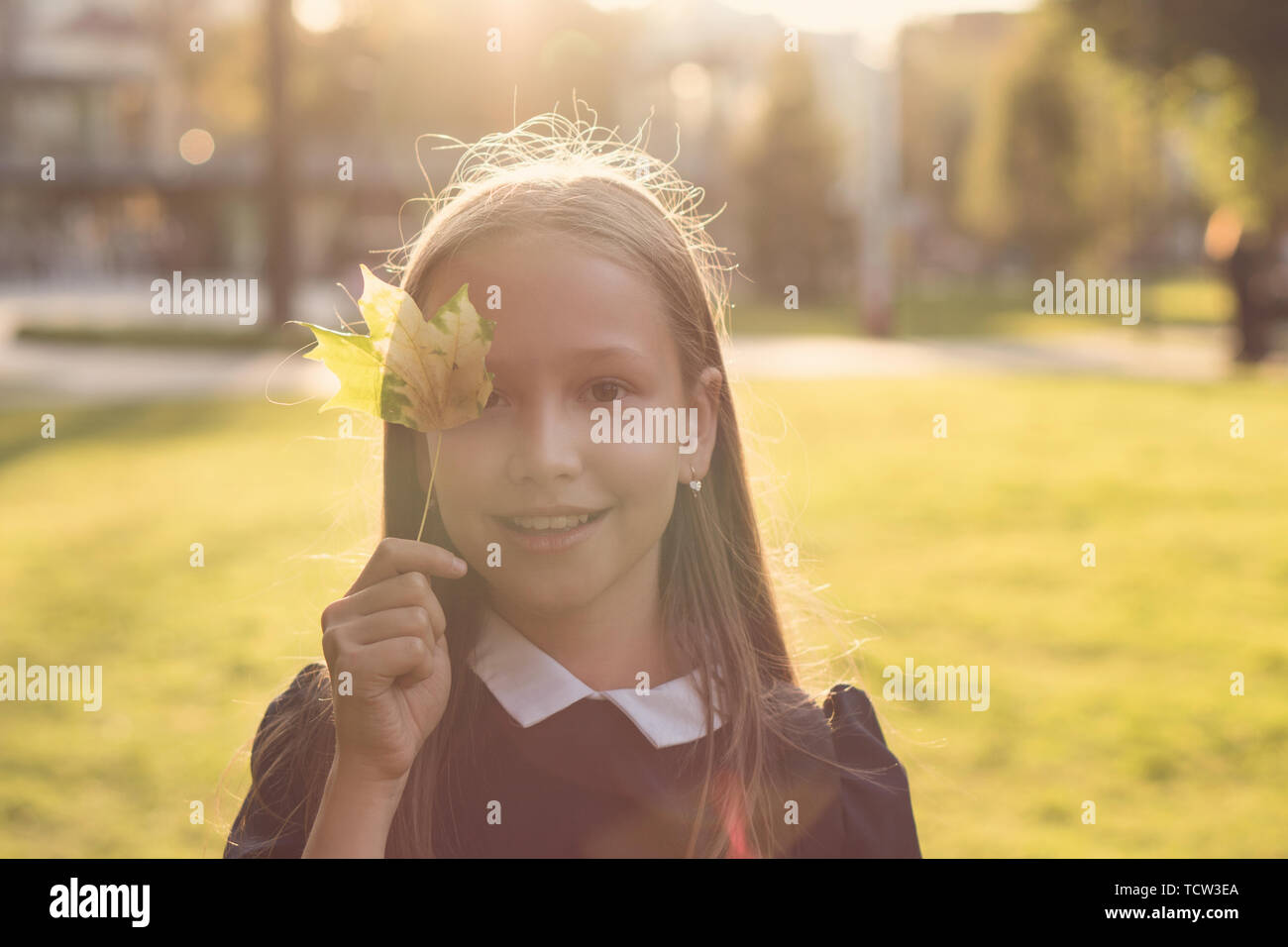 Portrait of european cute teen girl with maple leaf in her hands. She ...