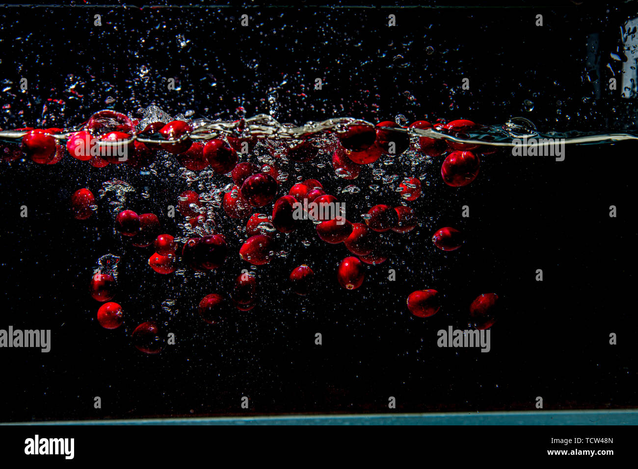 cranberries falling in dark water with splashes in the air Stock Photo ...