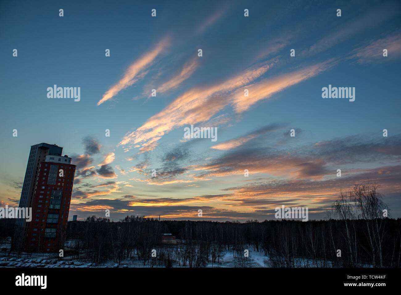 dramatic dark red clouds in sunset over countryside fields and forests ...