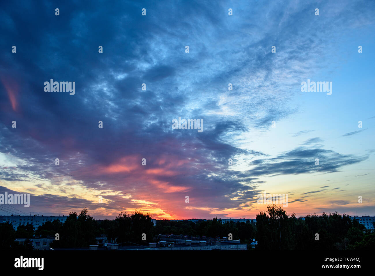 dramatic dark red clouds in sunset over countryside fields and forests ...