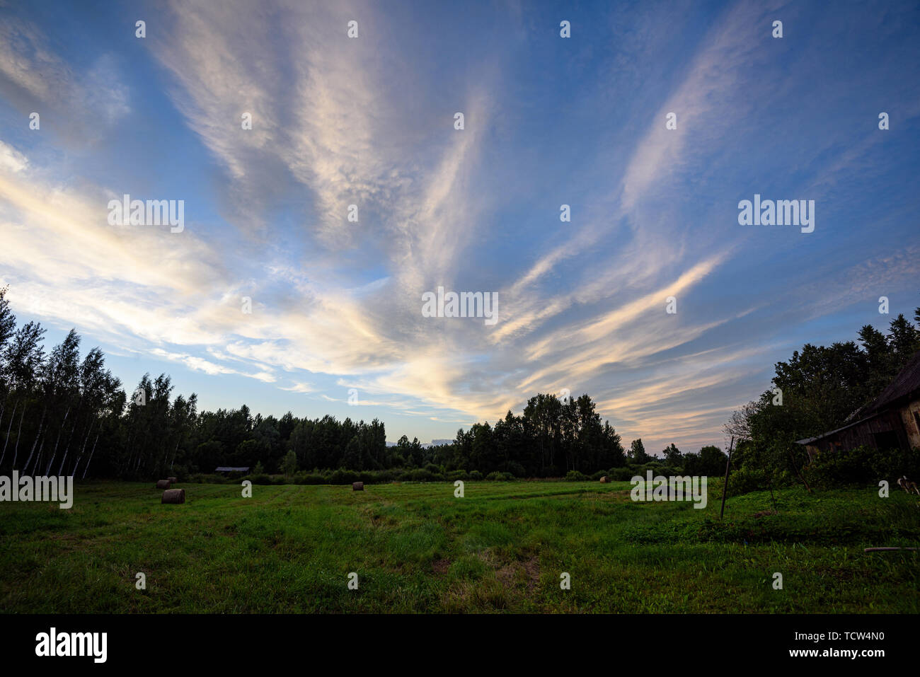 dramatic dark red clouds in sunset over countryside fields and forests ...