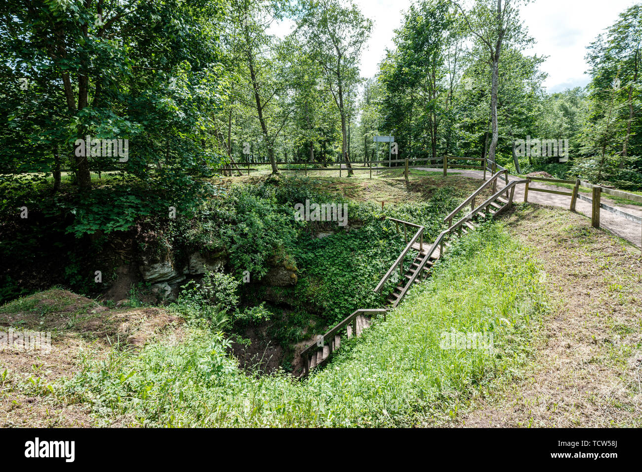 archeological pit cave in the ground in meadow. summer green nature ...