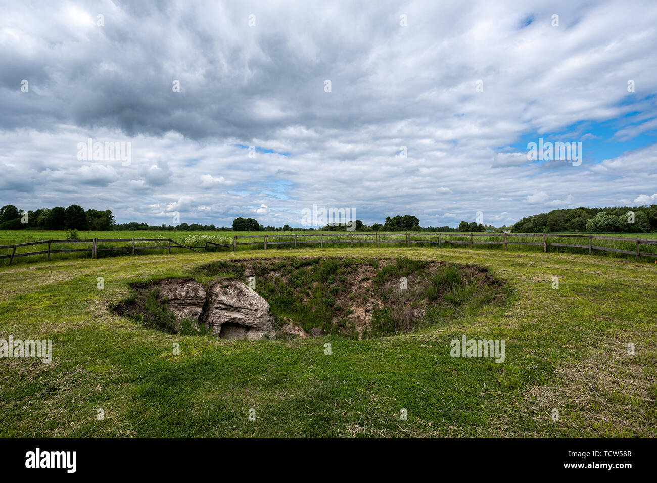 archeological pit cave in the ground in meadow. summer green nature ...