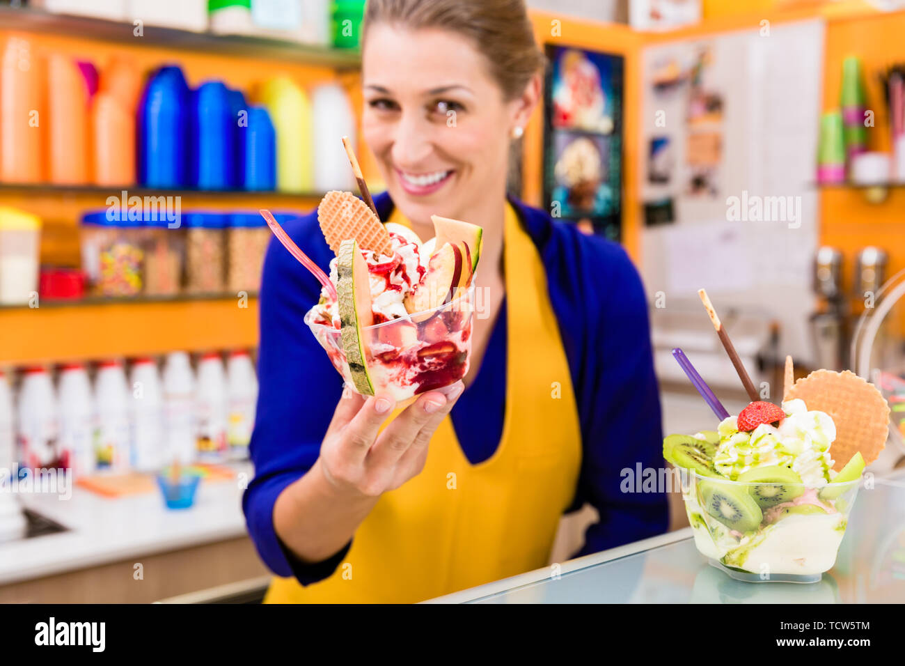 Woman in ice cream parlor presenting her newest sundae creation ...