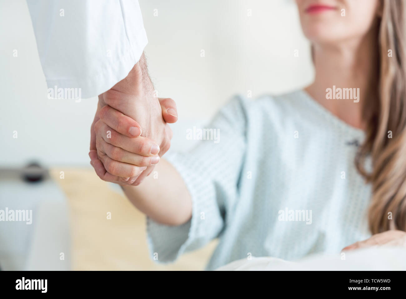 Doctor shaking hand of patient in hospital bed, closeup Stock Photo - Alamy