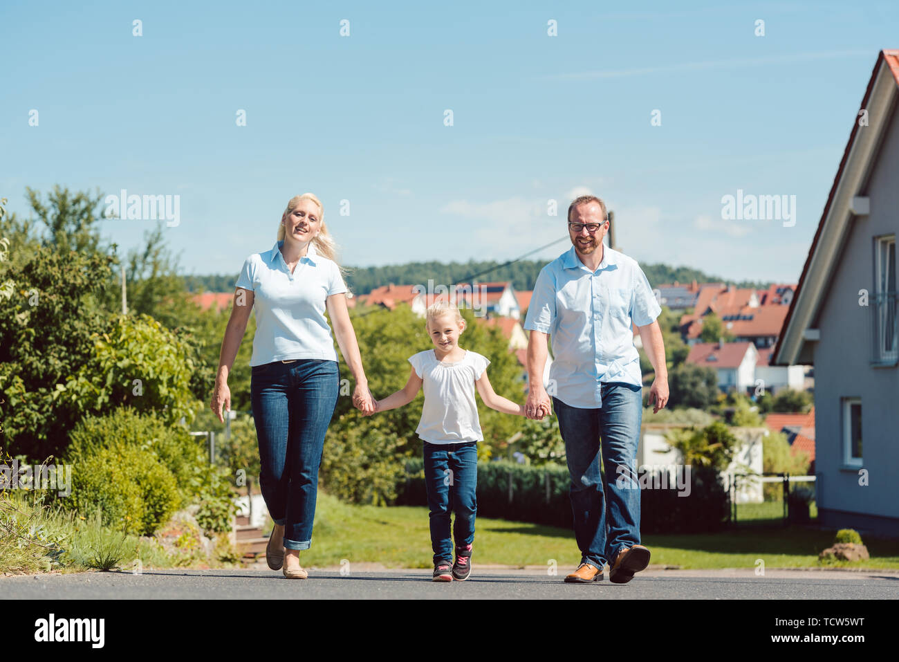 Family having walk in the village on summer day Stock Photo - Alamy