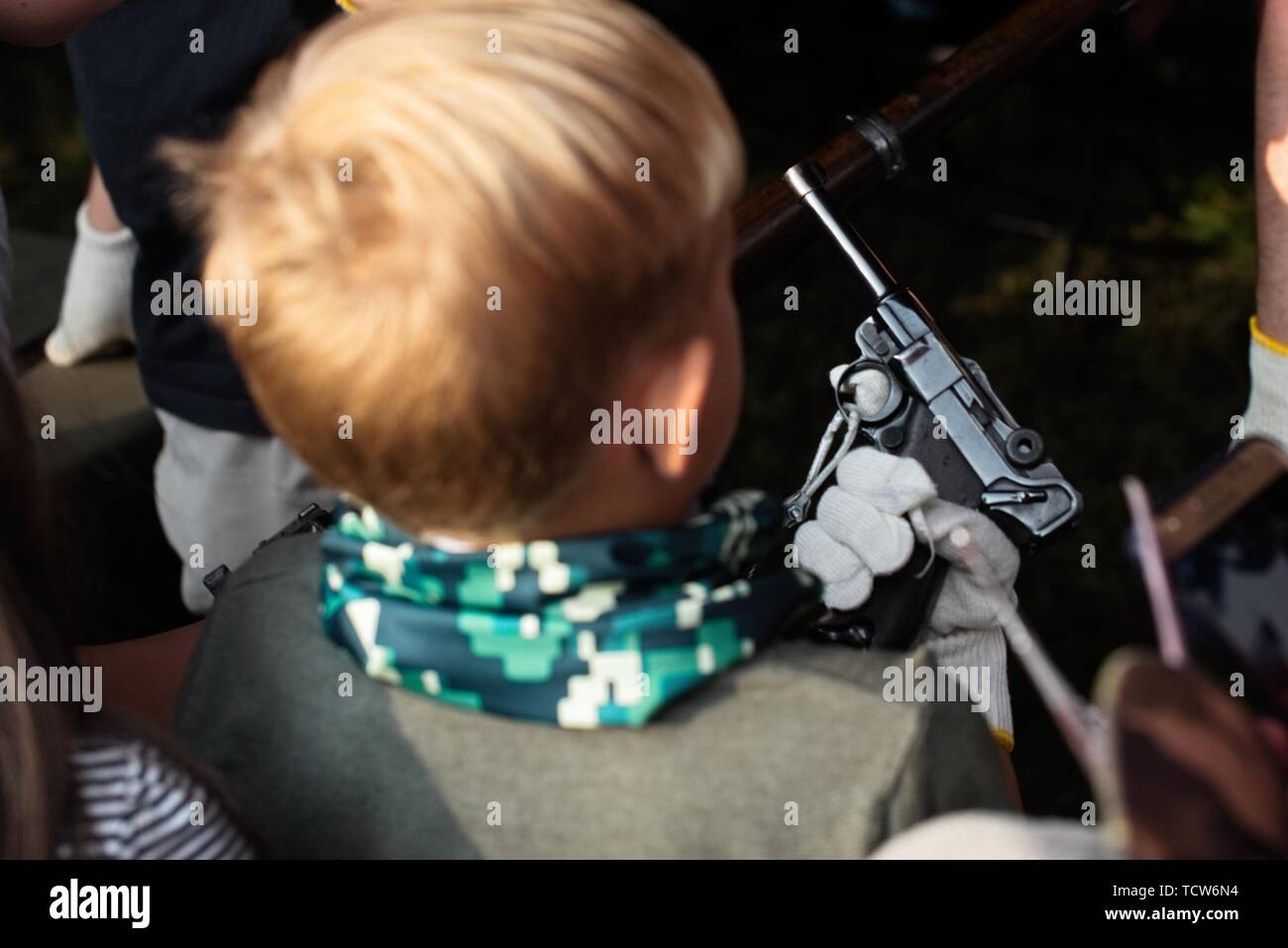 A boy with gun. Little boy holding real gun in the hand. Happy boy with ...