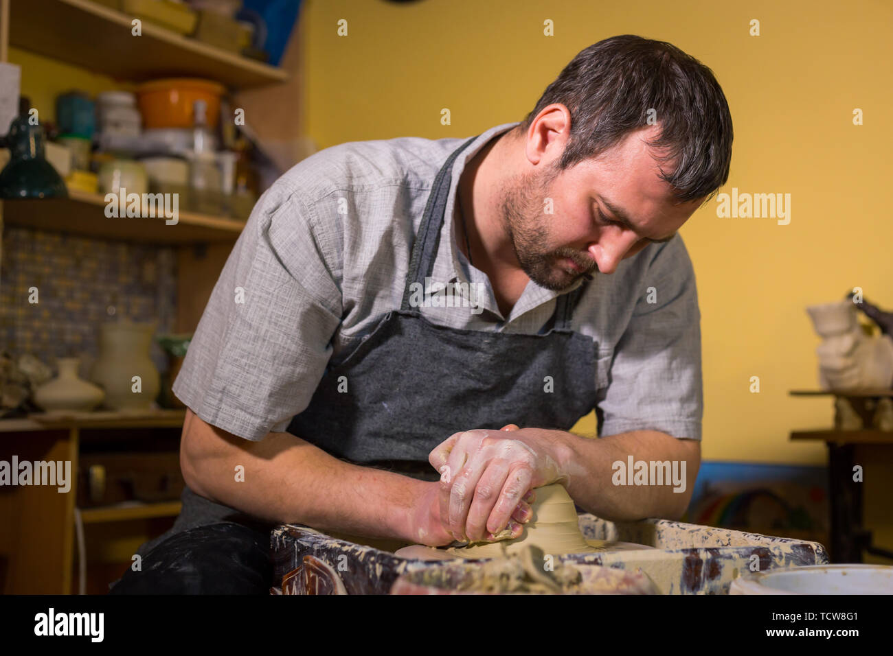 Professional male potter working with clay on potter's wheel Stock ...