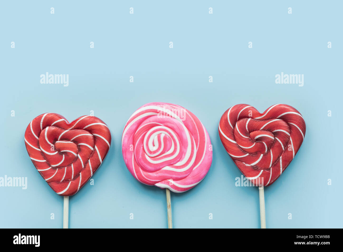 Three lollipops candy, swirl and heart on blue. Funny concept Stock ...