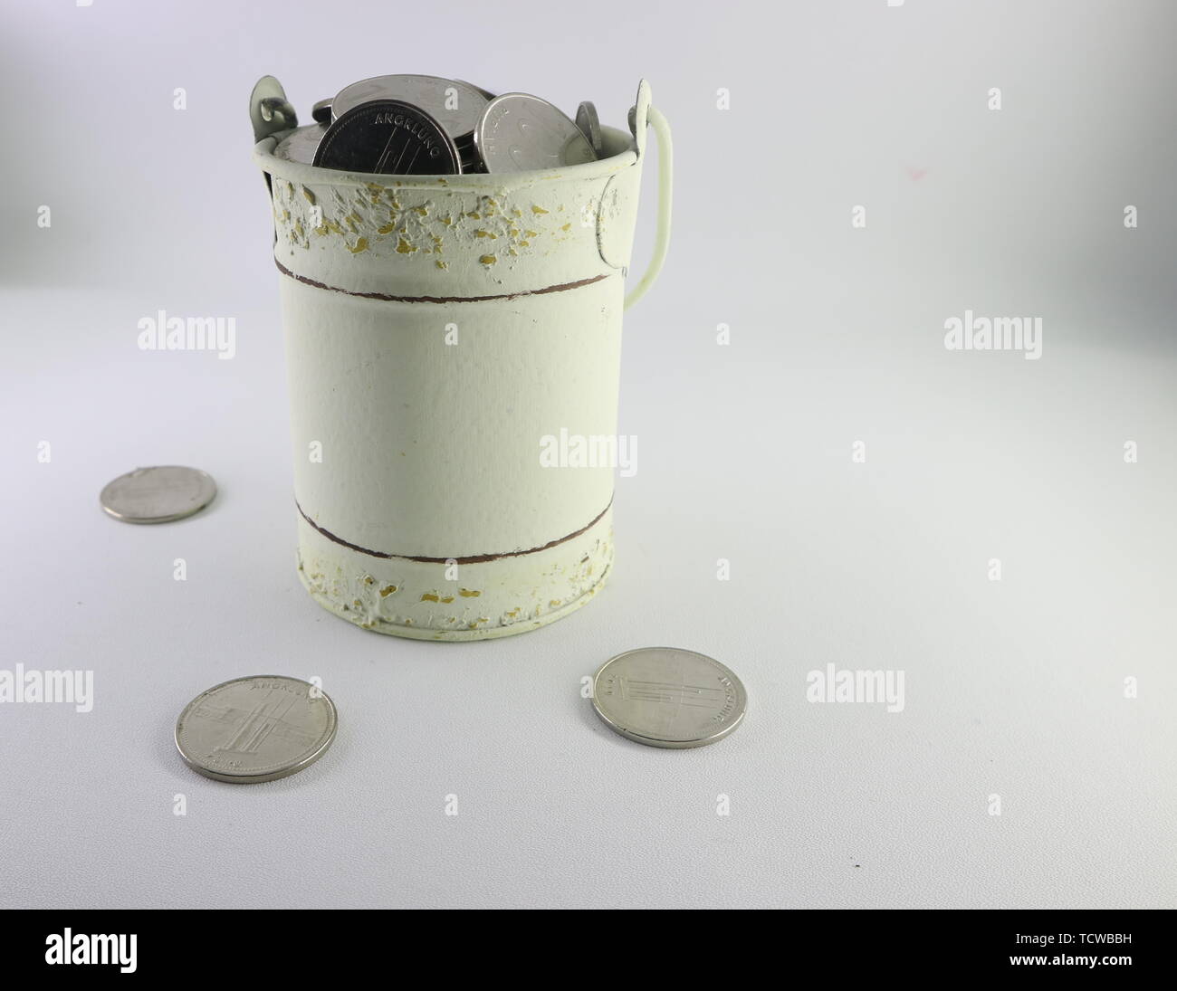 coin on the white bucket isolated on white background Stock Photo - Alamy