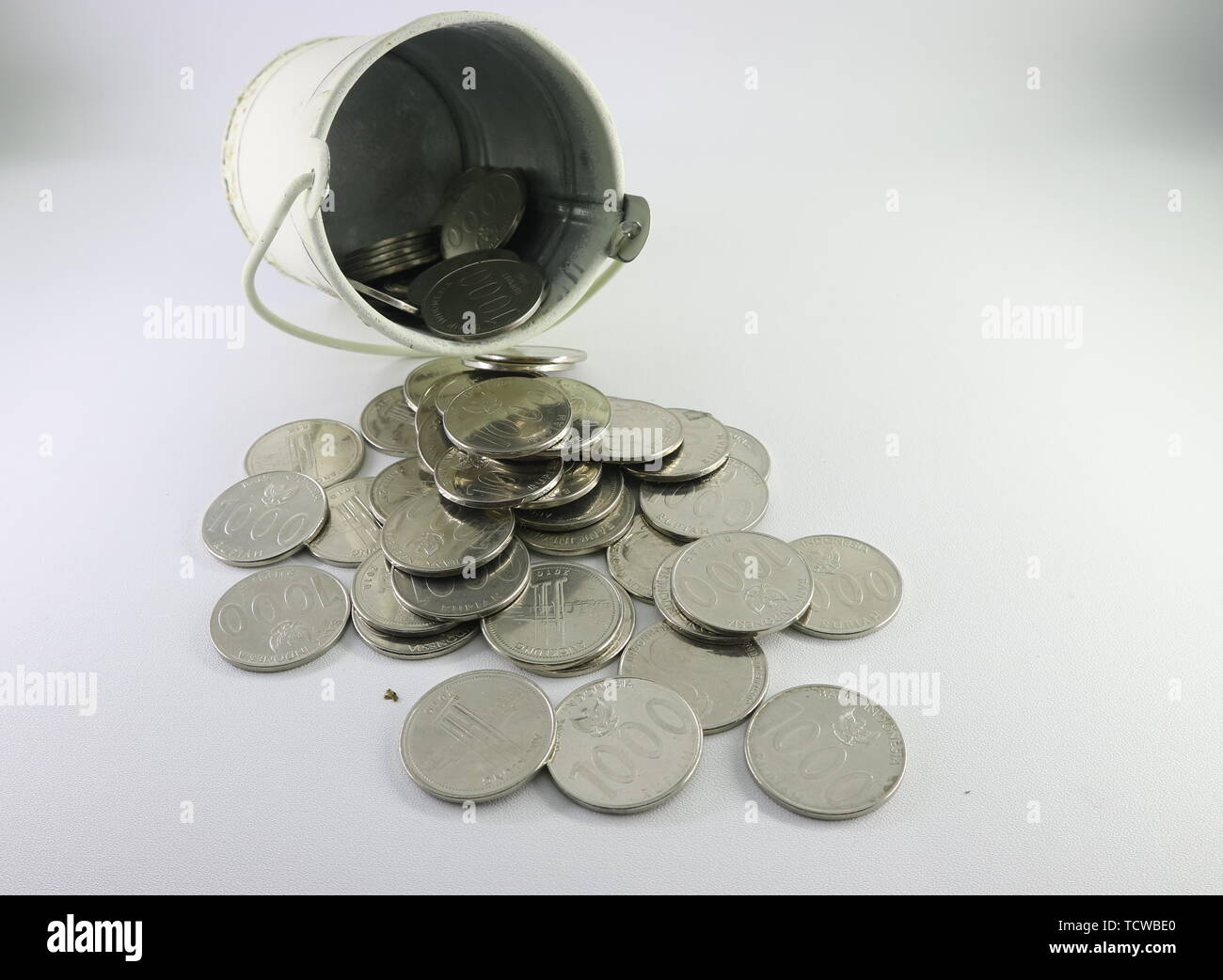 coin on the white bucket isolated on white background Stock Photo - Alamy