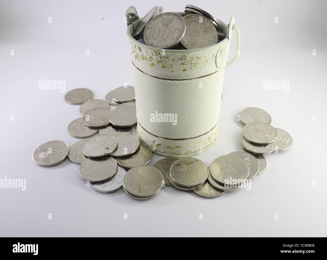 coin on the white bucket isolated on white background Stock Photo - Alamy