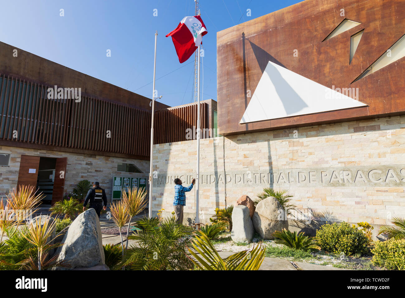 Flag raising outside municipal offices in Paracas, Peru, South America ...