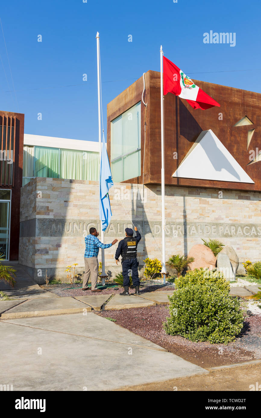 Flag raising outside municipal offices in Paracas, Peru, South America ...