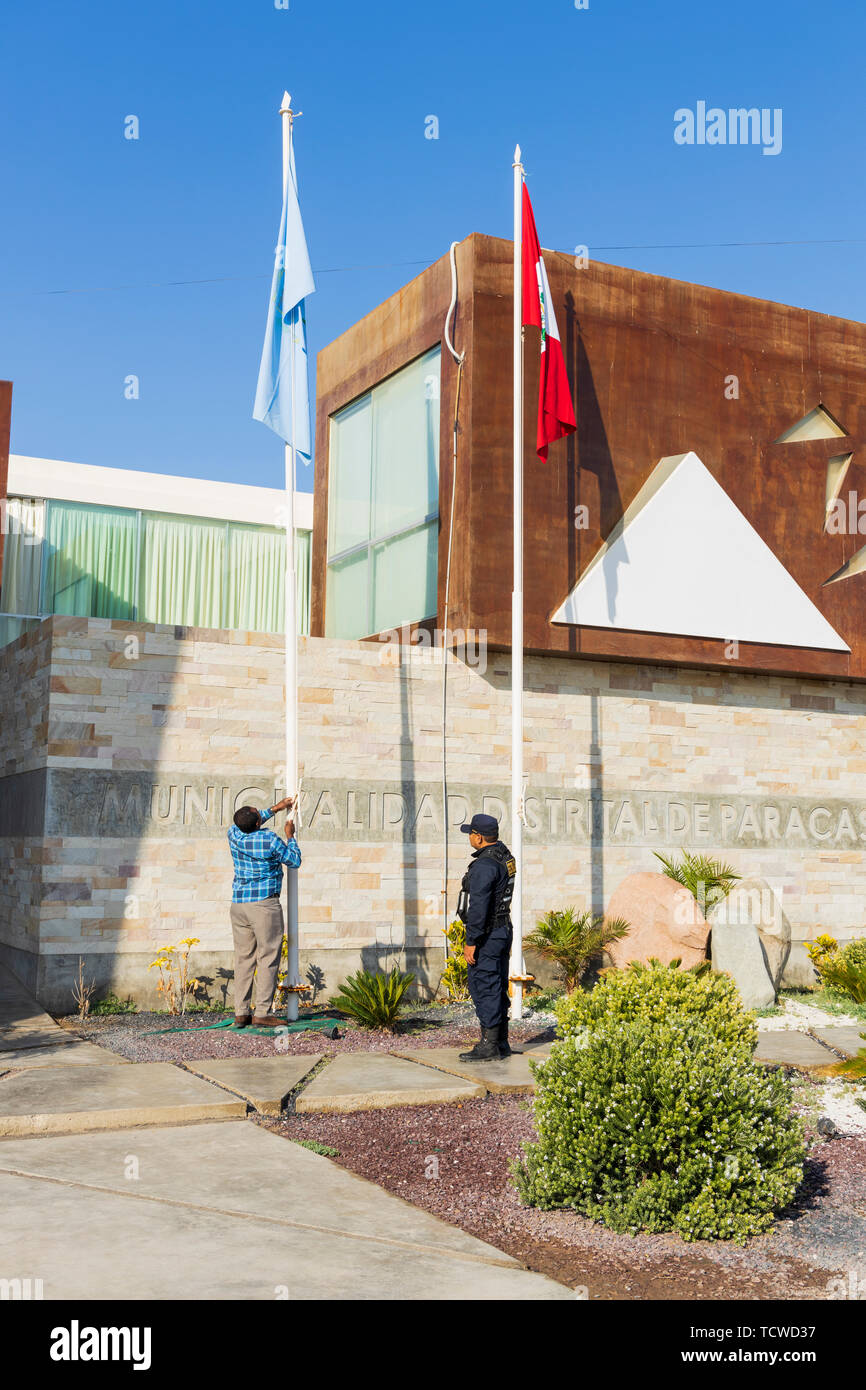Flag raising outside municipal offices in Paracas, Peru, South America ...