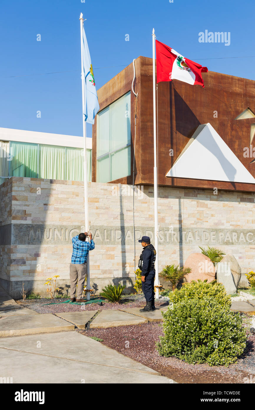 Flag raising outside municipal offices in Paracas, Peru, South America ...