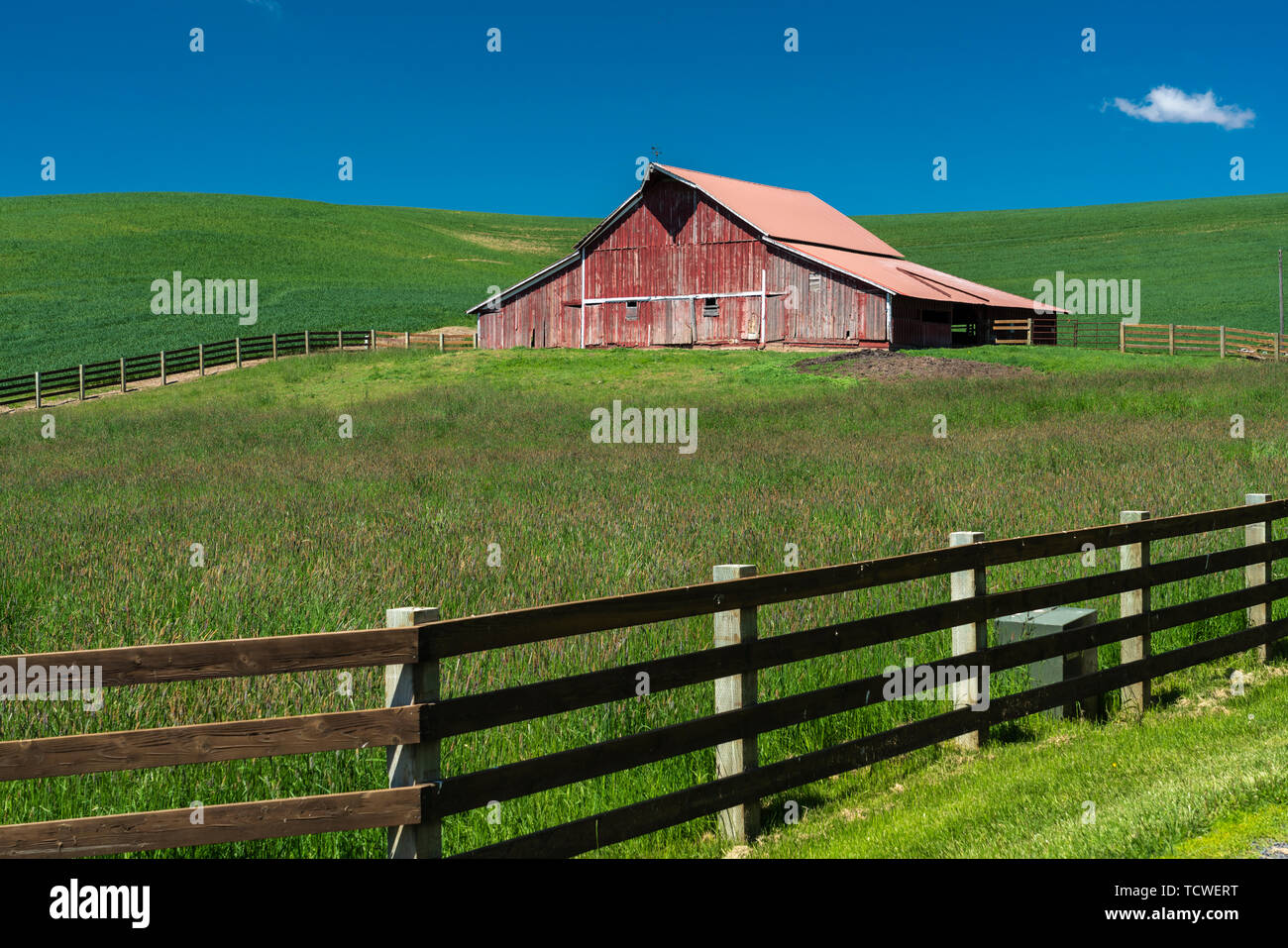 A red barn in the rolling hills of the Palouse region of Washington ...