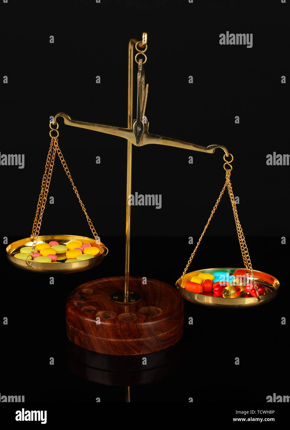 Classic scales with color pills isolated on black Stock Photo - Alamy