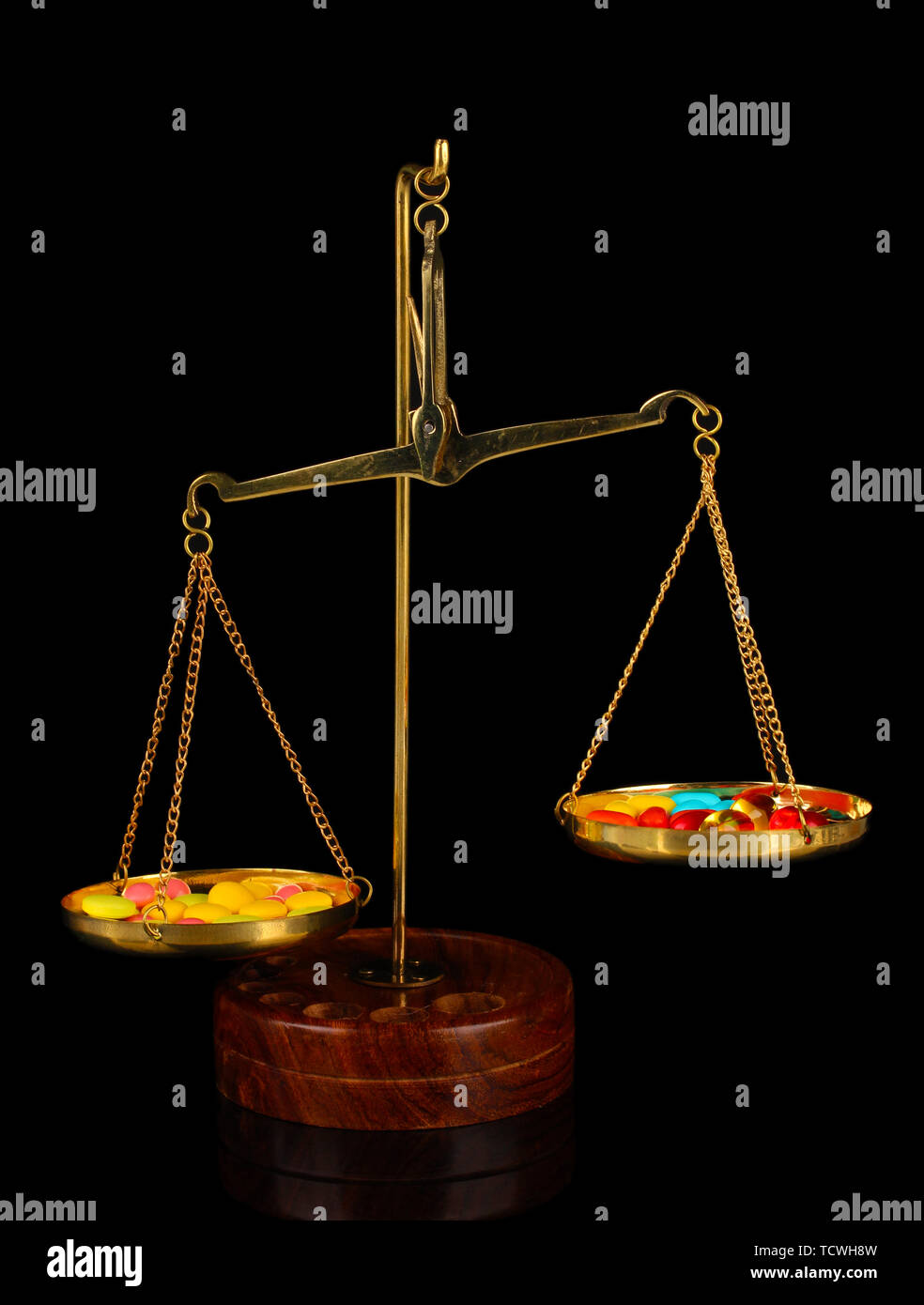 Classic scales with color pills isolated on black Stock Photo - Alamy