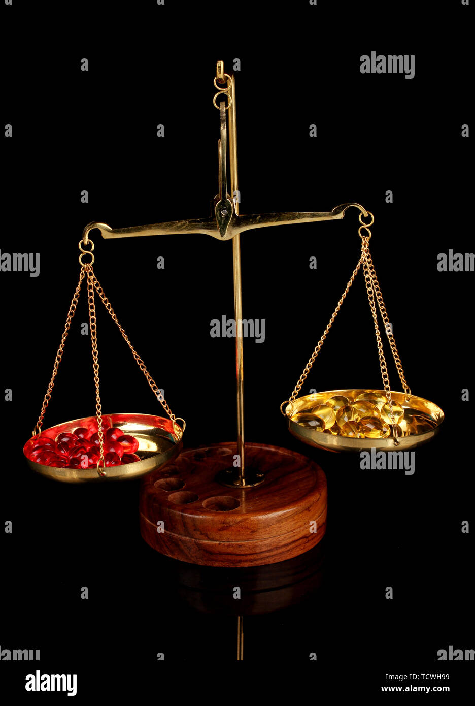 Classic scales with color pills isolated on black Stock Photo - Alamy