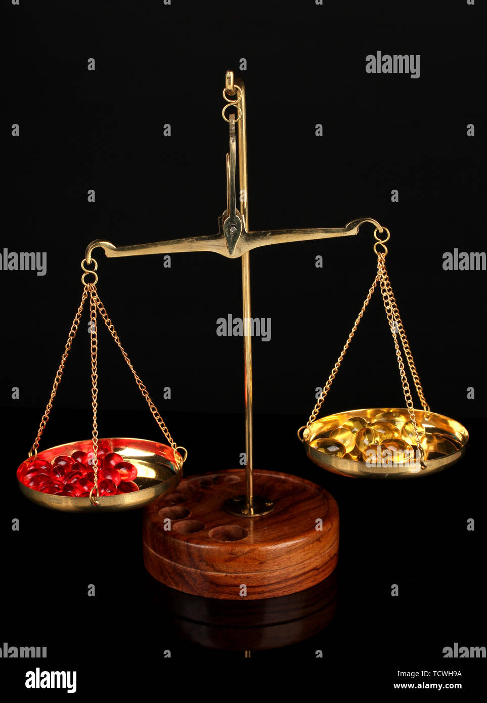 Classic scales with color pills isolated on black Stock Photo - Alamy