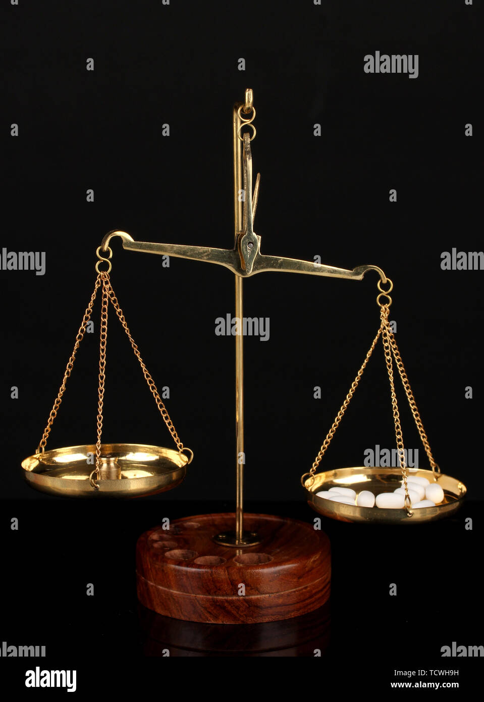 Classic scales with color pills isolated on black Stock Photo - Alamy