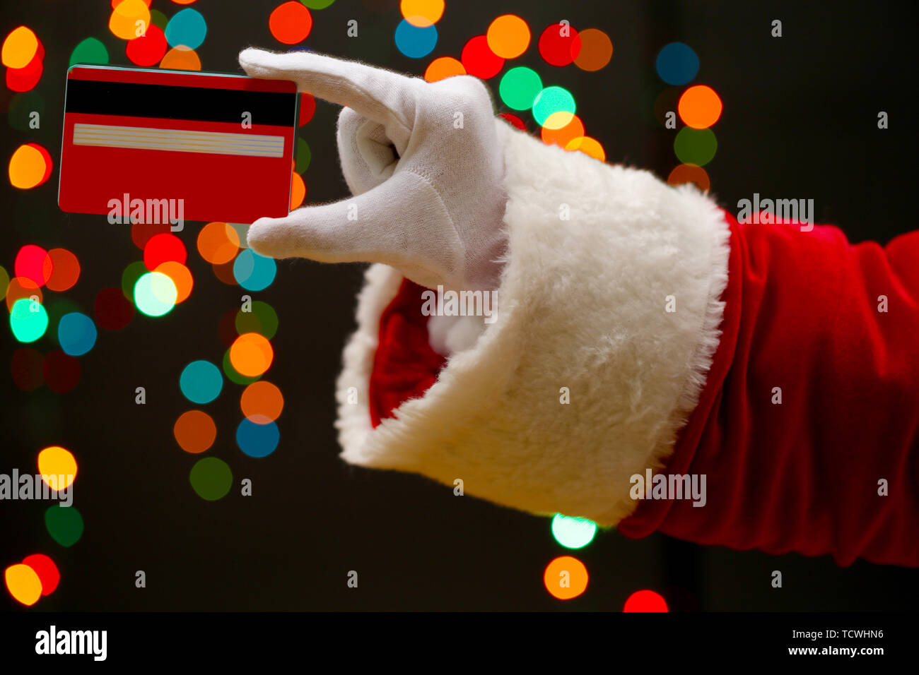 Santa Claus hand holding credit card, on garland background Stock Photo ...