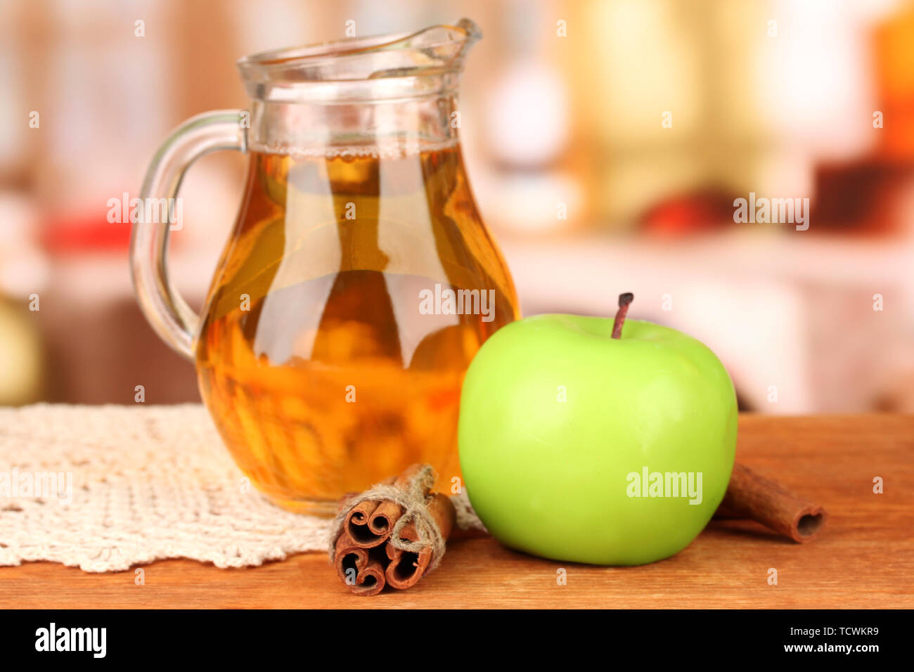 Full jug of apple juice and apple on wooden table on bright background ...