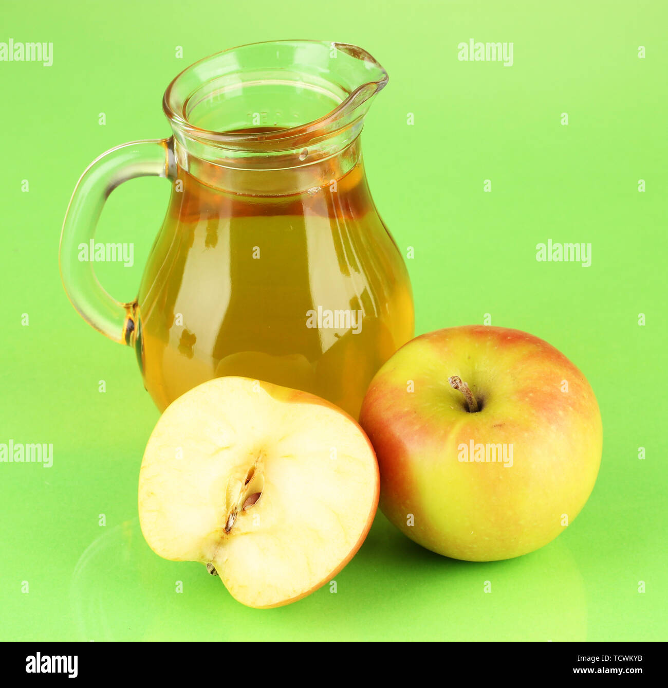 Full jug of apple juice and apple on color background Stock Photo - Alamy