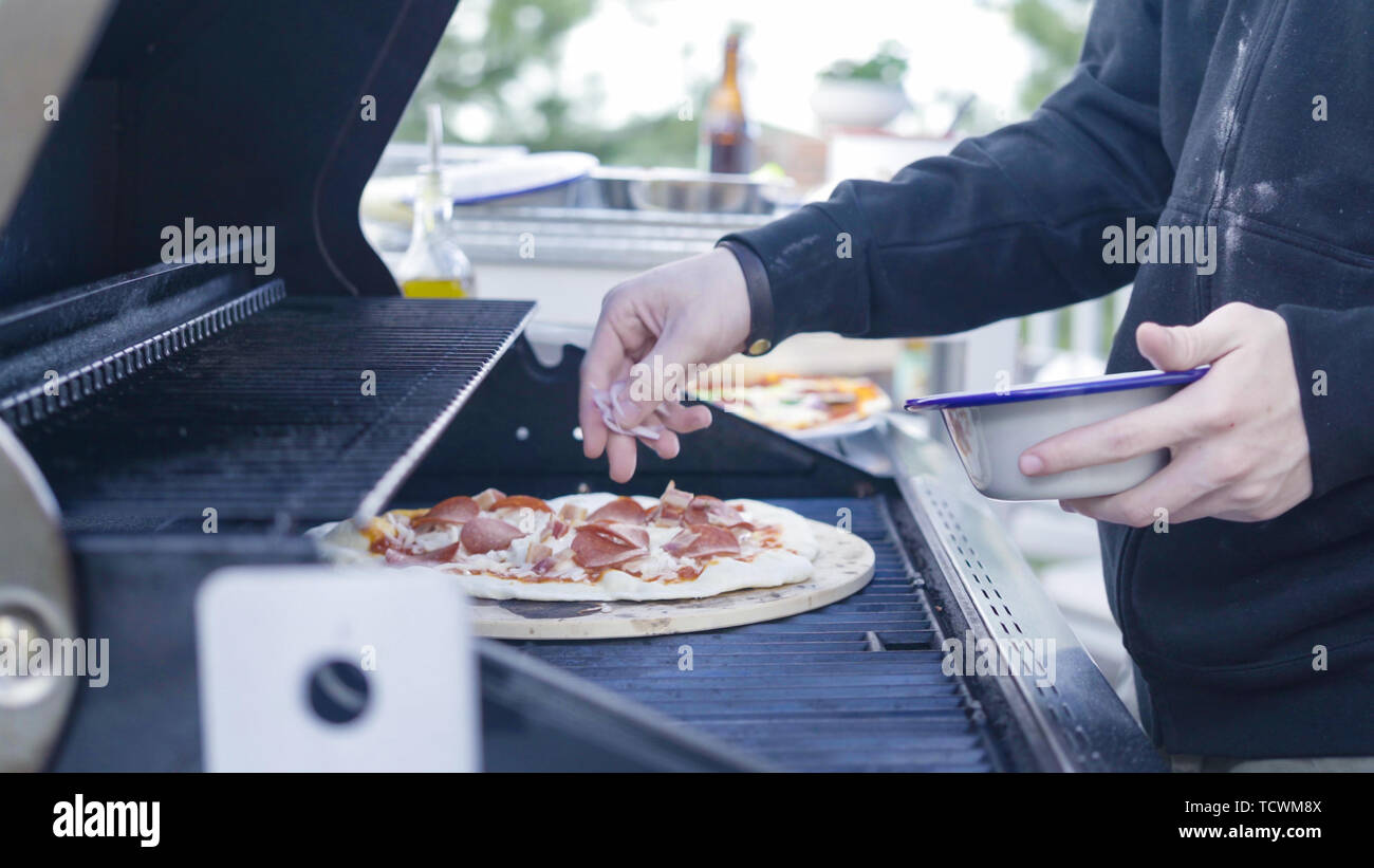 Cooking pizza on outdoor gas grill Stock Photo - Alamy