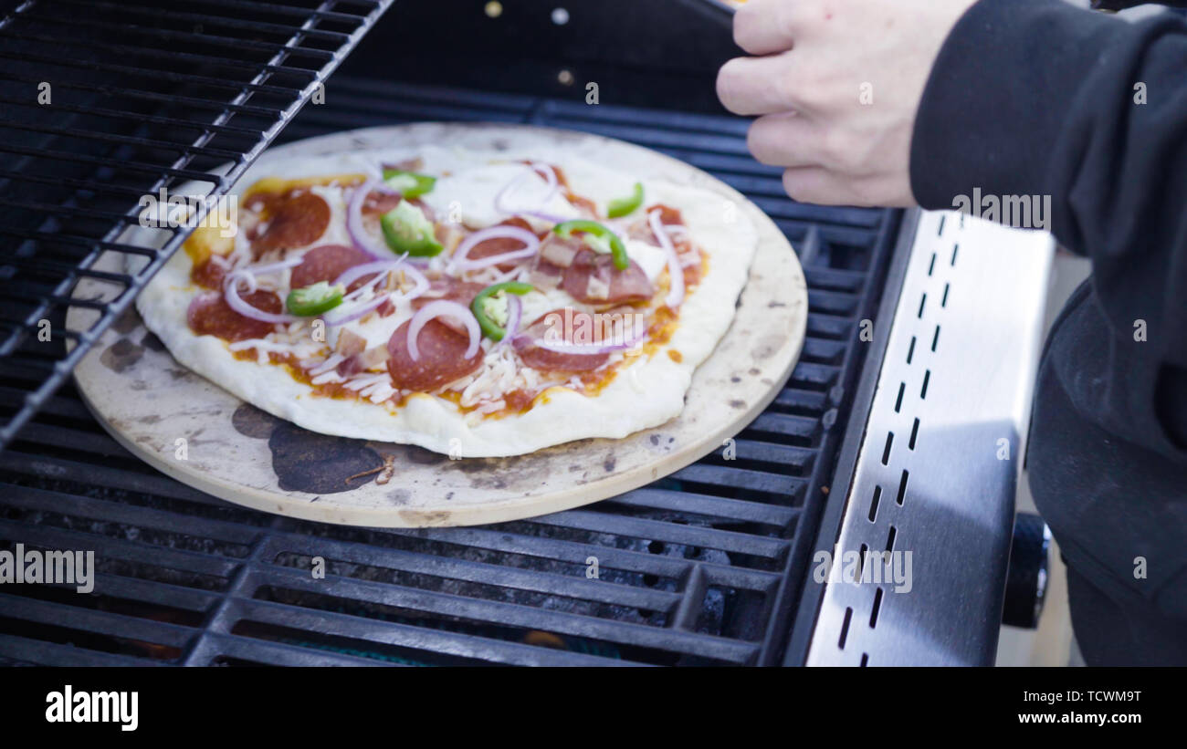 Cooking pizza on outdoor gas grill Stock Photo - Alamy