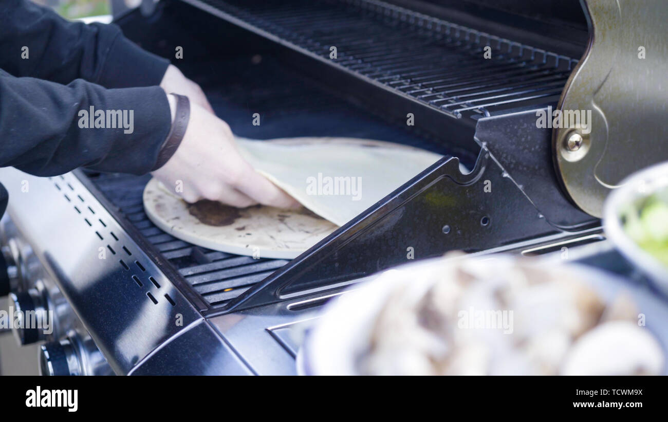 Cooking pizza on outdoor gas grill Stock Photo - Alamy