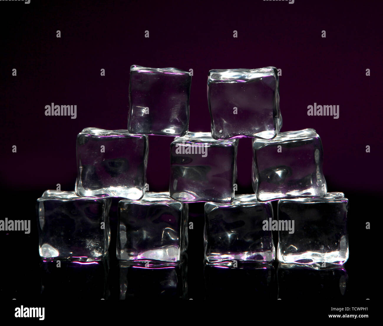Ice cubes on dark purple background Stock Photo - Alamy