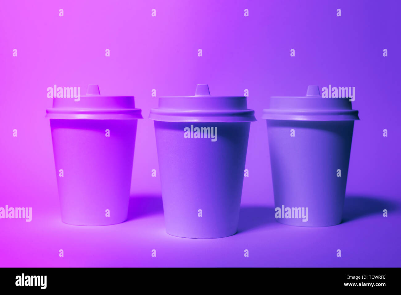 Paper disposable cups in trendy neon light Stock Photo - Alamy