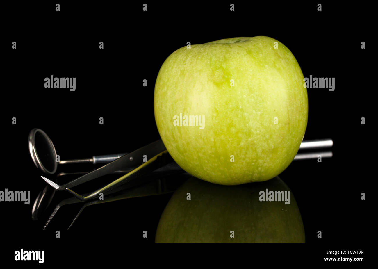Green apple and dental tools isolated on black Stock Photo - Alamy