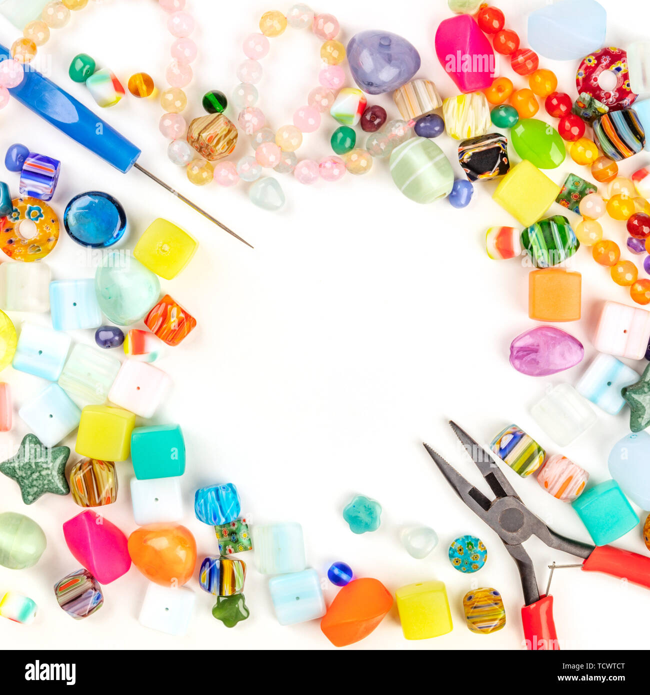 A square photo of beads with tools for making jewelry, shot from above ...