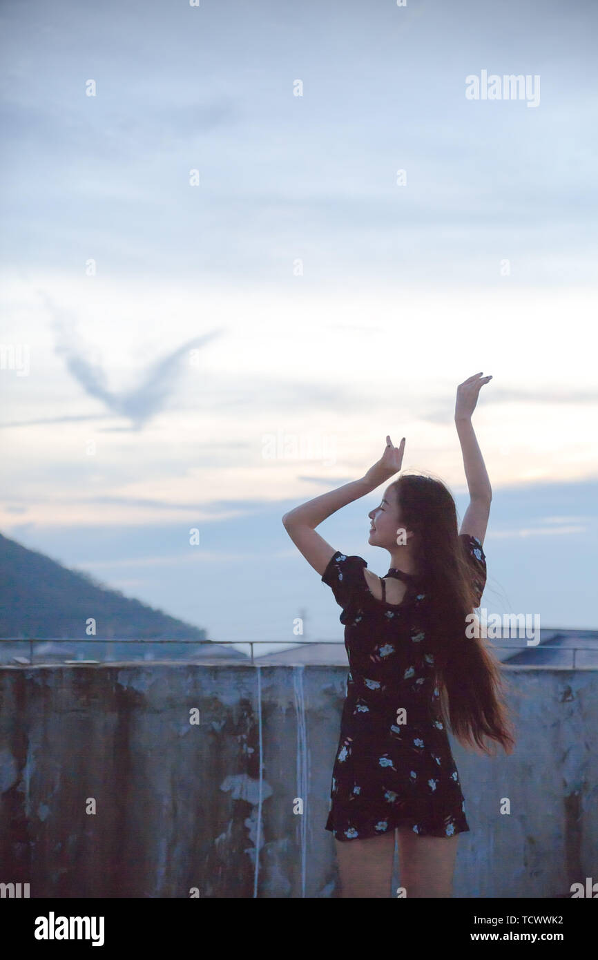 Cloud rooftop sky dusk girl girl Stock Photo - Alamy