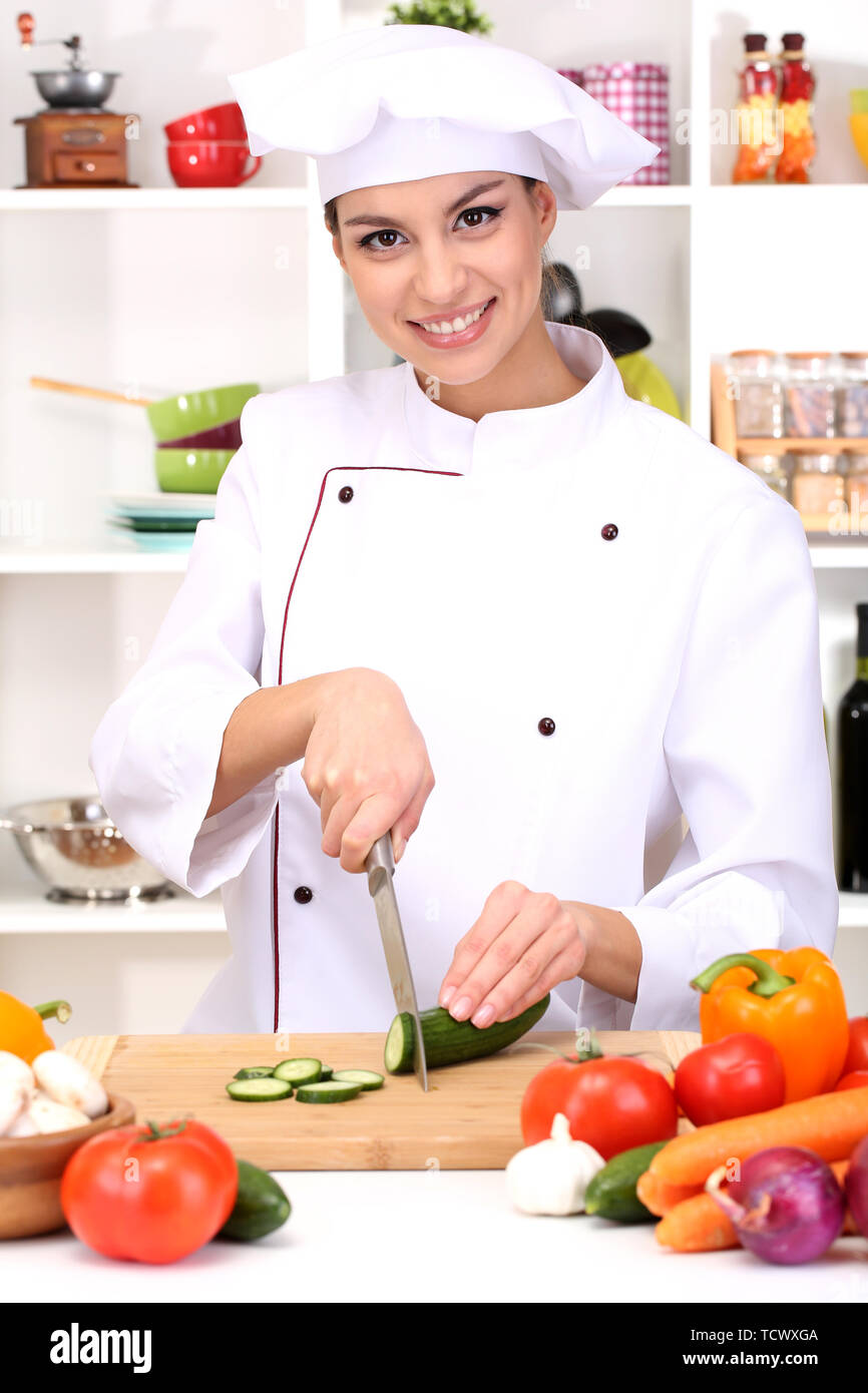 Young woman chef cooking in kitchen Stock Photo - Alamy