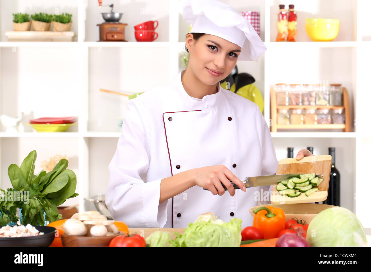 Young woman chef cooking in kitchen Stock Photo - Alamy