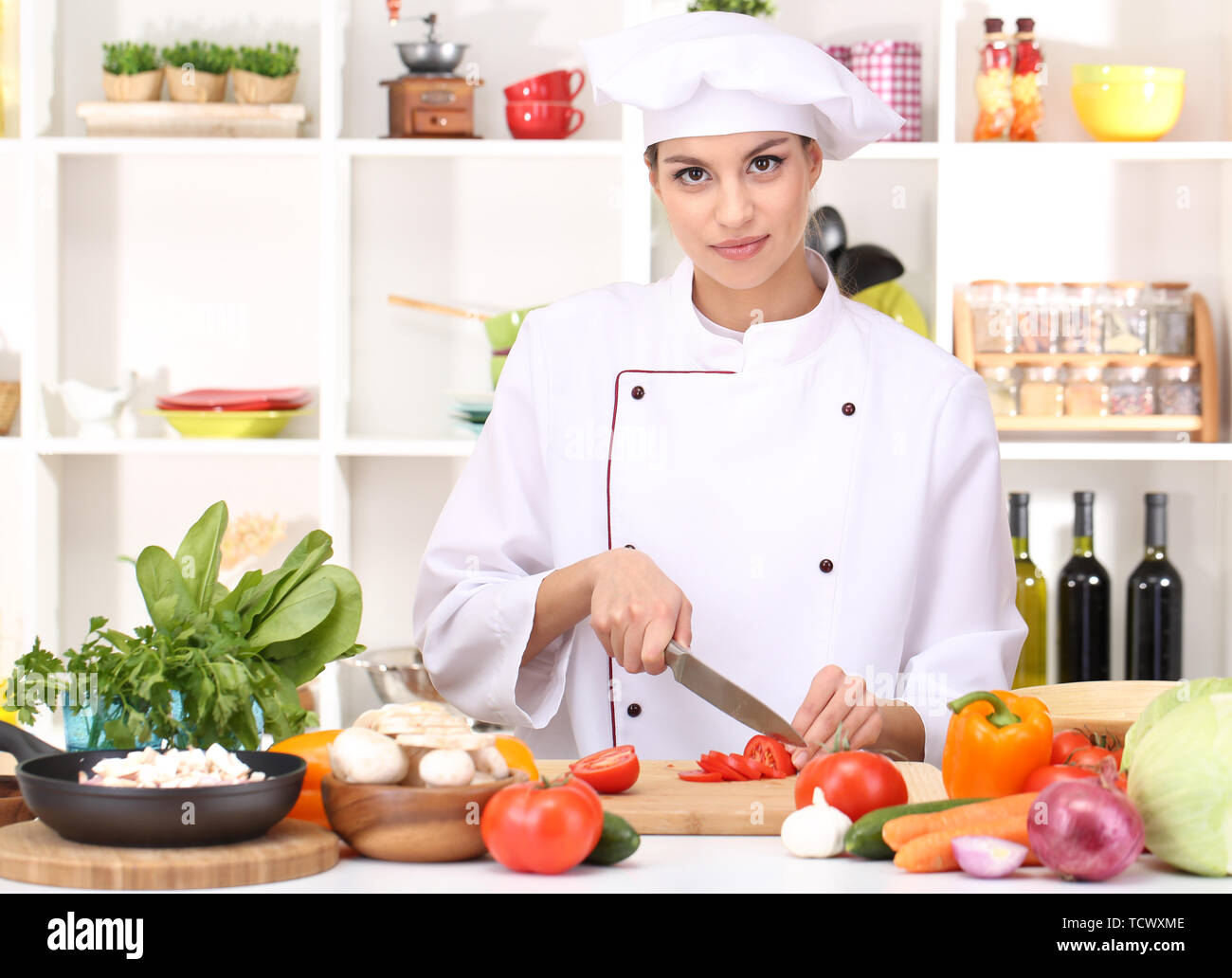 Young woman chef cooking in kitchen Stock Photo - Alamy